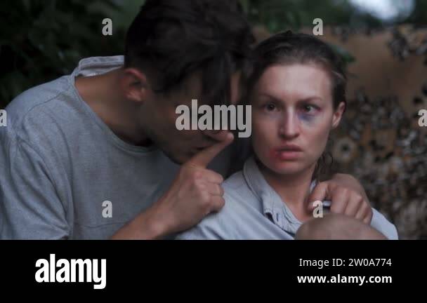 Aggressor husband hugs his victim - a woman with a small child in her ...