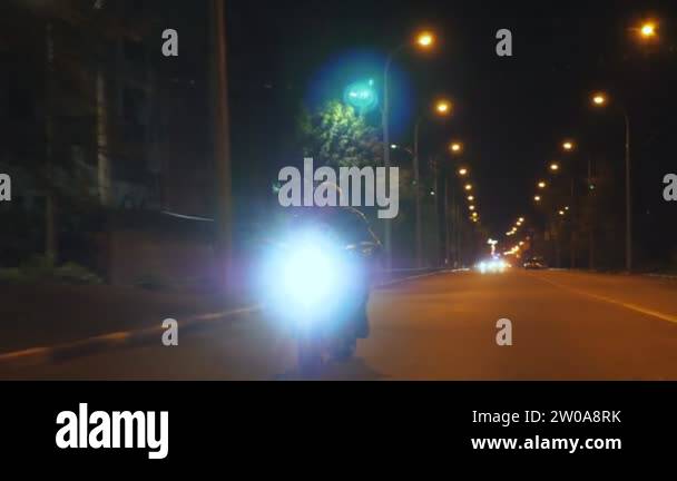 Man riding on modern sport motorbike with headlights on at night ...