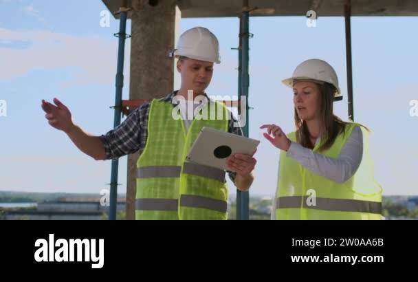 Construction worker man and architect woman in a helmet, discuss the ...