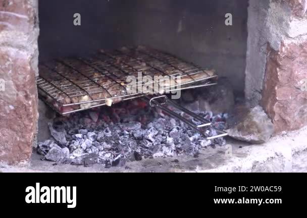 Lamb ribs are fried on fire BBQ and charcoal in a barbecue grill ...