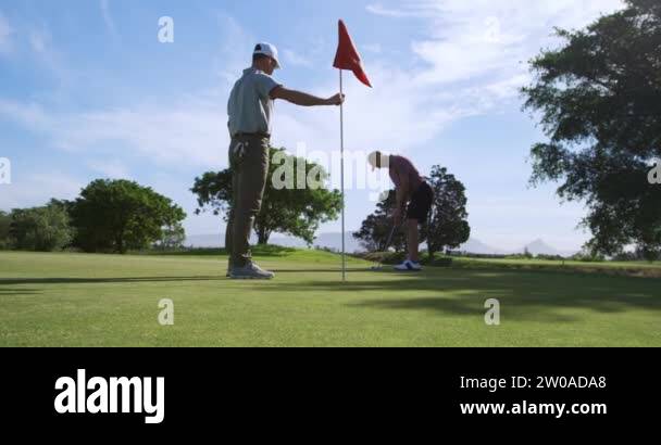 Two Caucasian male golfers on a golf course wearing caps and golf ...