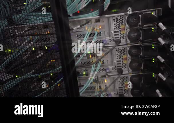 Close up fiber optic and hub in server room. Blinking rays of light ...