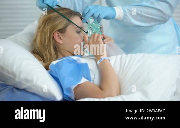 Nurse wearing female patient oxygen mask, preparation before surgery ...