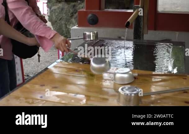 4K Religious people washing hands in shinto water ablution pavilion for ...