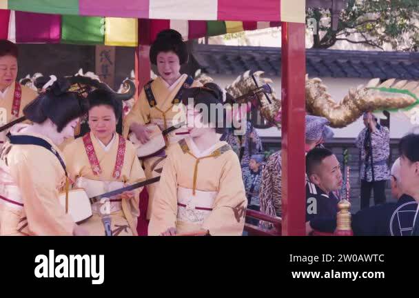 Static video of cart in which sit musicians playing drums, flute and ...