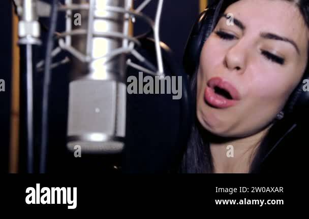 Young beautiful girl sings.Young singer singing into a microphone ...