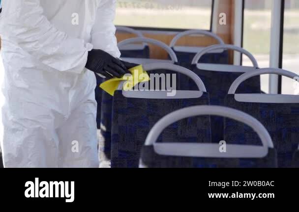Hazmat team worker disinfects bus interior with antibacterial sanitizer ...