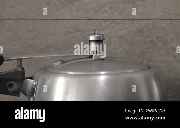Pressure cook with steam and vapor coming out of whistle and raising it ...