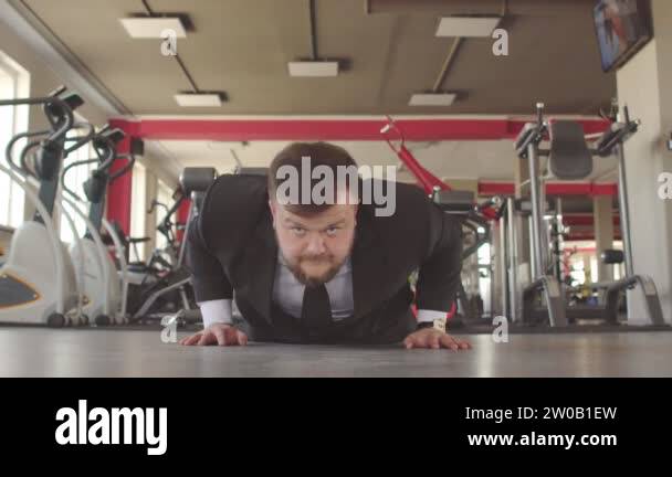 A male caucasian businessman in a black suit performs physical ...