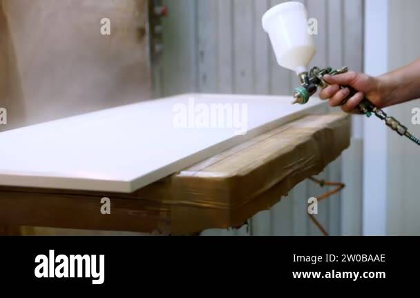 close-up. Staining wood with spray gun. Painter using airbrush to paint ...