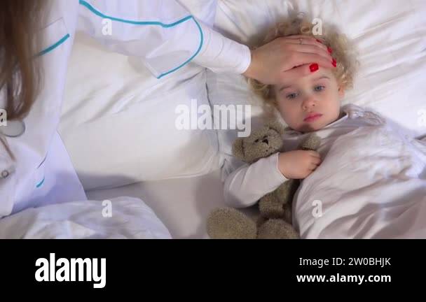 little sick feverish girl lying in bed with nursing care in bedroom. 4K ...