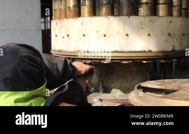 Worker is disassembly mechanism of obsolete machine using Allen key. H.264 video codec Stock ...
