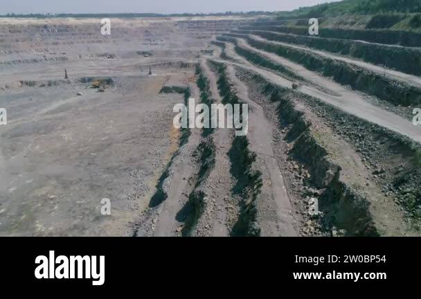 Mining dump trucks in large granite open pit mine. Empty truck rides on ...