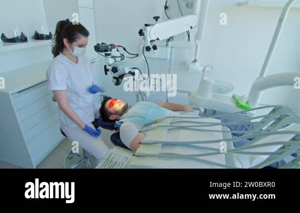 Dentist examining patients teeth through dental microscope Stock Video ...