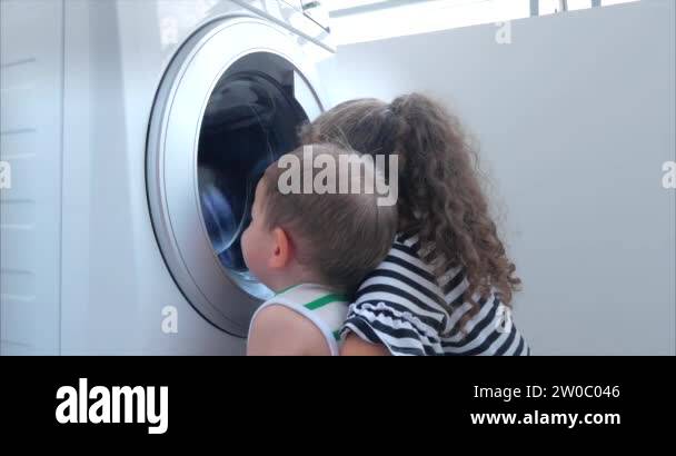 Cute Child Looks Inside the Washing Machine. Cylinder Spinning Machine ...