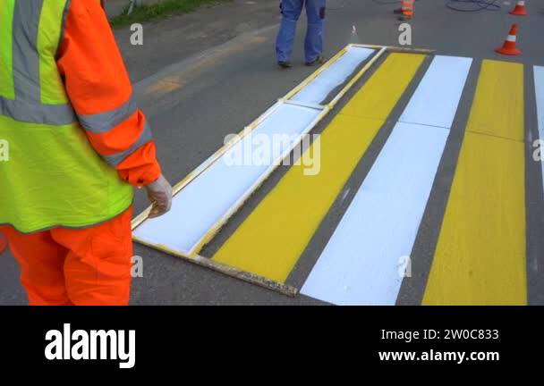 Road marking. Painting road lines. Workers draw white and yellow ...