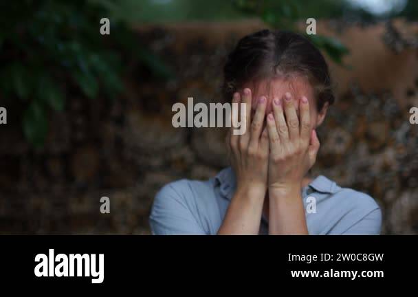 Frightened battered woman looking into the camera and covers his face ...