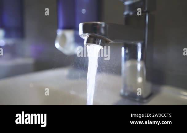 Hot tap water. Warm water flows from the tap in the bathroom ...