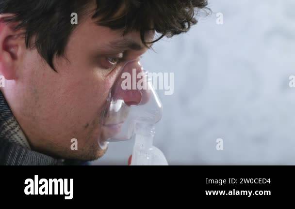 Use nebulizer and inhaler for the treatment. Sick man inhaling through ...