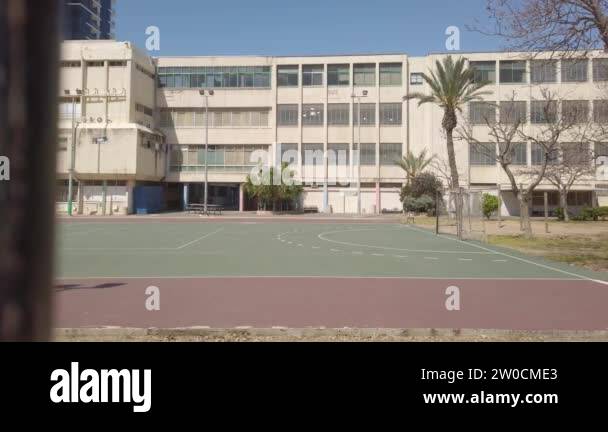 Camera pull out from school to a gate or metal fence - empty school ...