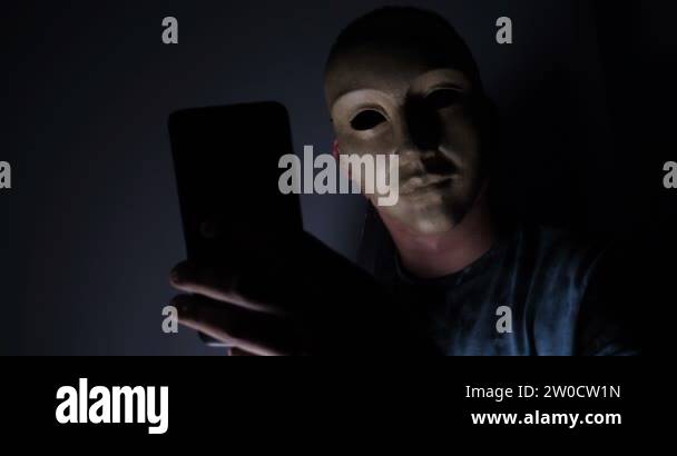 Male hacker hidden face with the mask accessing to personal information ...