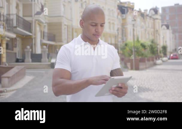 Portrait of handsome confident bald middle eastern man typing on the ...