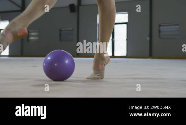 Side view close up of a focused teenage Caucasian female gymnast performing at sports hall ...