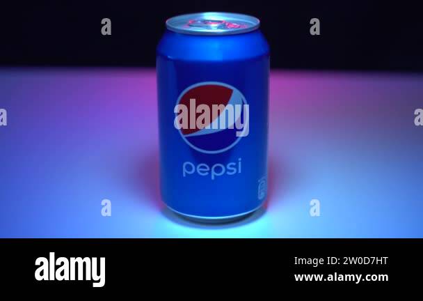 A blue Pepsi can on a light surface with a white backlight that moves ...
