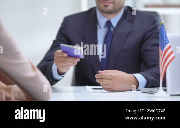 American consular officer giving passport to female immigrant, refugee ...