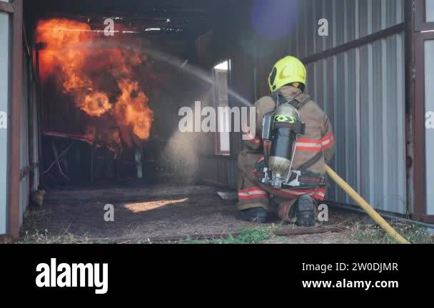 Rear view of Fireman wear fire protection suit sit in the fire training ...