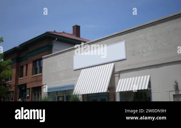 Establishing shot of tan bricked business with generic blank signage ...