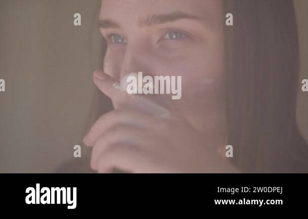 Close-up of young woman with long hair sniffing cocaine. Female face is ...