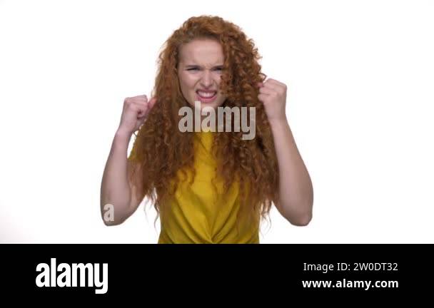 Angry young redhead curly woman screaming very loud and gesturing with ...