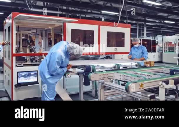 Workers inside modern factory background. Production of new details in ...