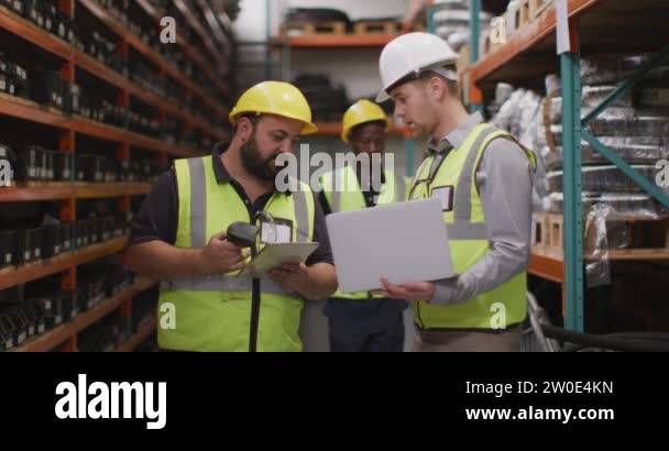 Two Caucasian male factory workers at a factory making hydraulic ...
