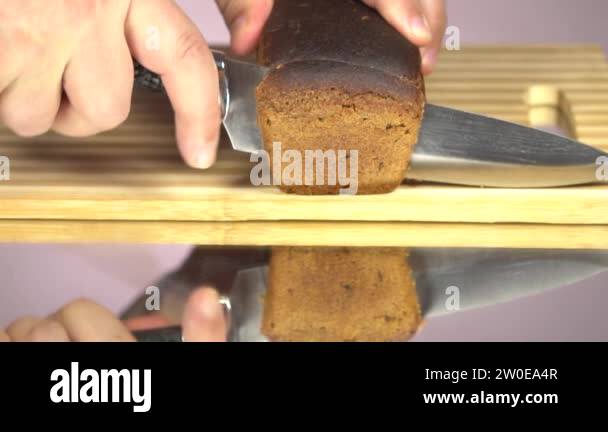 front view of brick of bread. Mans hand take off a front part of bread ...