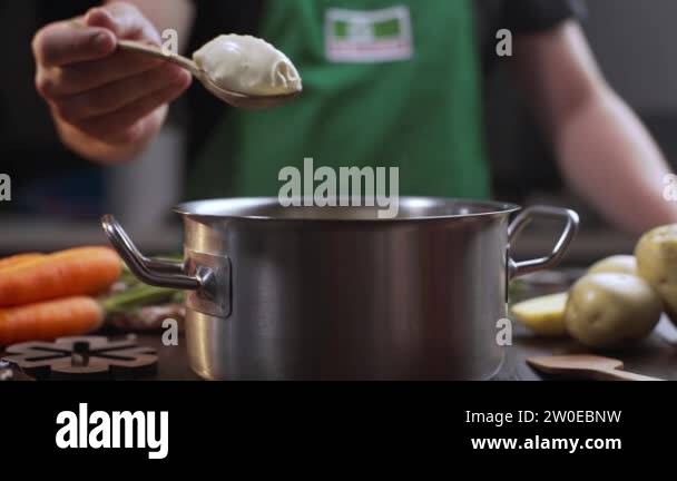 Chef adds cream cheese to the meal while cooking, the cook puts some ...
