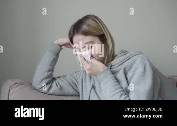 Close-up. The blonde girl with short hair is sick, sneezes and wraps ...