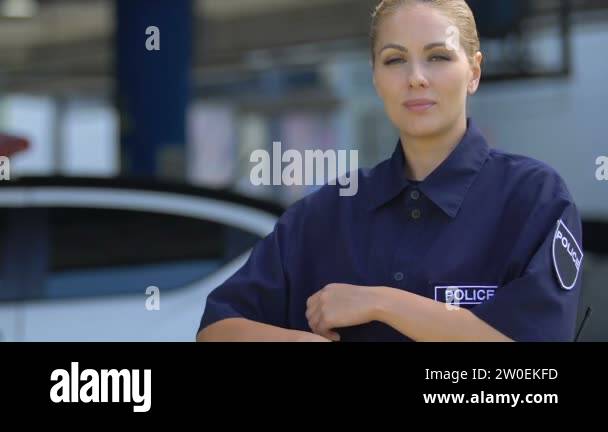 Pretty female police officer smiling into camera, kind helpful cop on ...