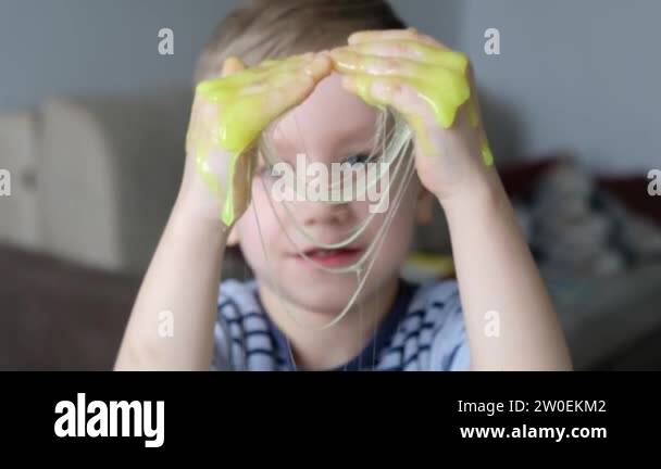 Cute kid boy playing with light green slime. Close up Stock Video ...