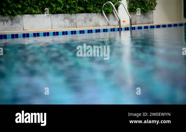 Swimming pool with stairs and wooden deck at luxury hotel. blue pool ...