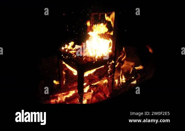Cinemagraph of wooden chair burning inside the bonfire. Close up on ...