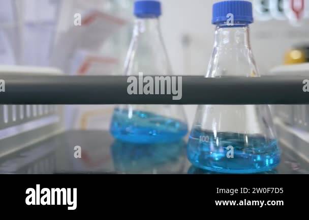 Glass flasks in the laboratory. Stir the blue substance. Medical laboratory makes analyzes ...