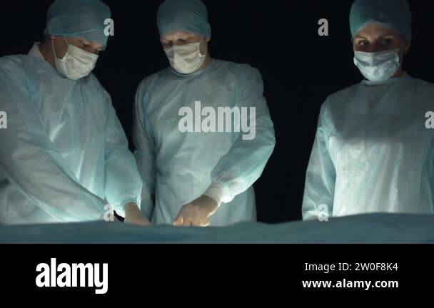 A surgical team operate on a patient during procedure. Physician with ...