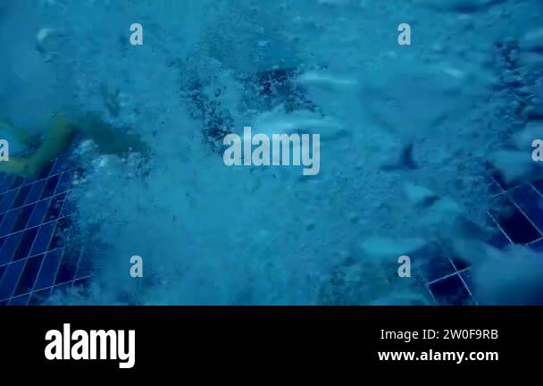 Slow motion video of man diving underwater in aqua park pool releases ...