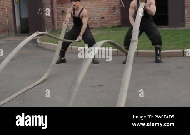 Two attractive muscular young men training and perform crossfit ...