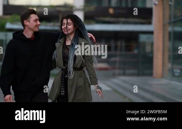 Young happy loving couple walking outdoors at the street having fun. Couple Holding Hands ...