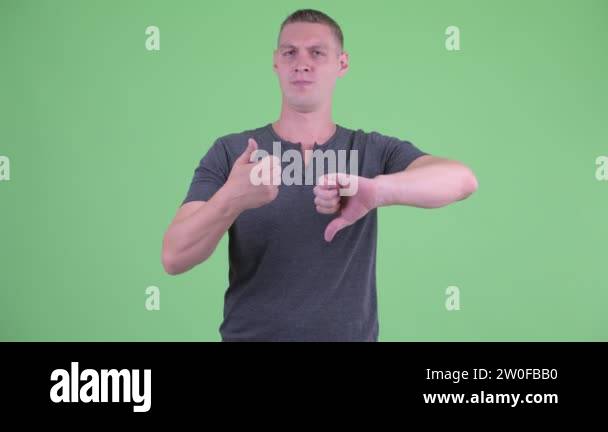 Confused young man choosing between thumbs up and thumbs down Stock ...