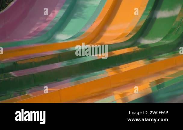 A Close-up of Different Colored Water Slides with People Racing Down on ...