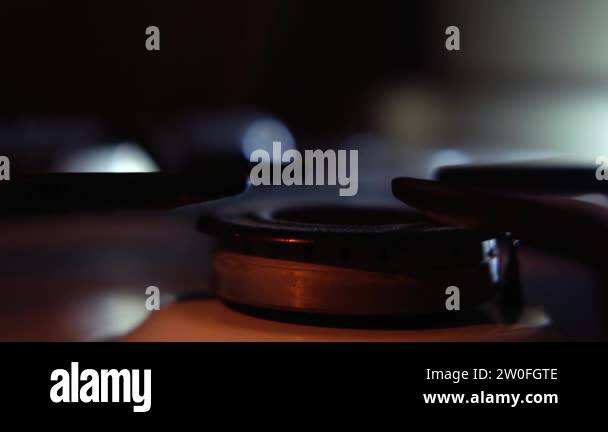 A man lights a gas stove with a match, close-up. Close up on the flame ...